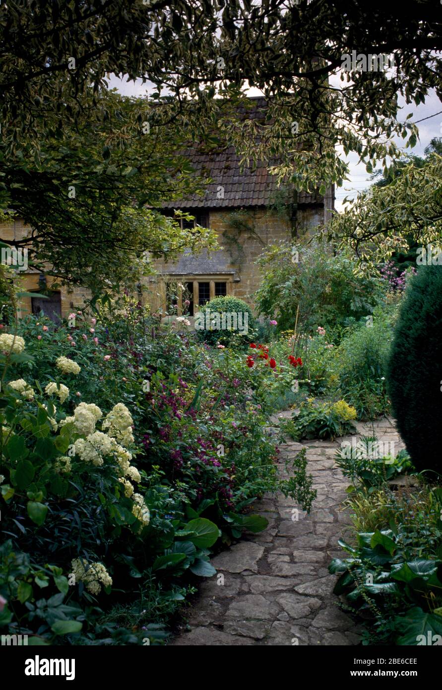 Cotswold stone house with mixed shrub and perennial border with ...