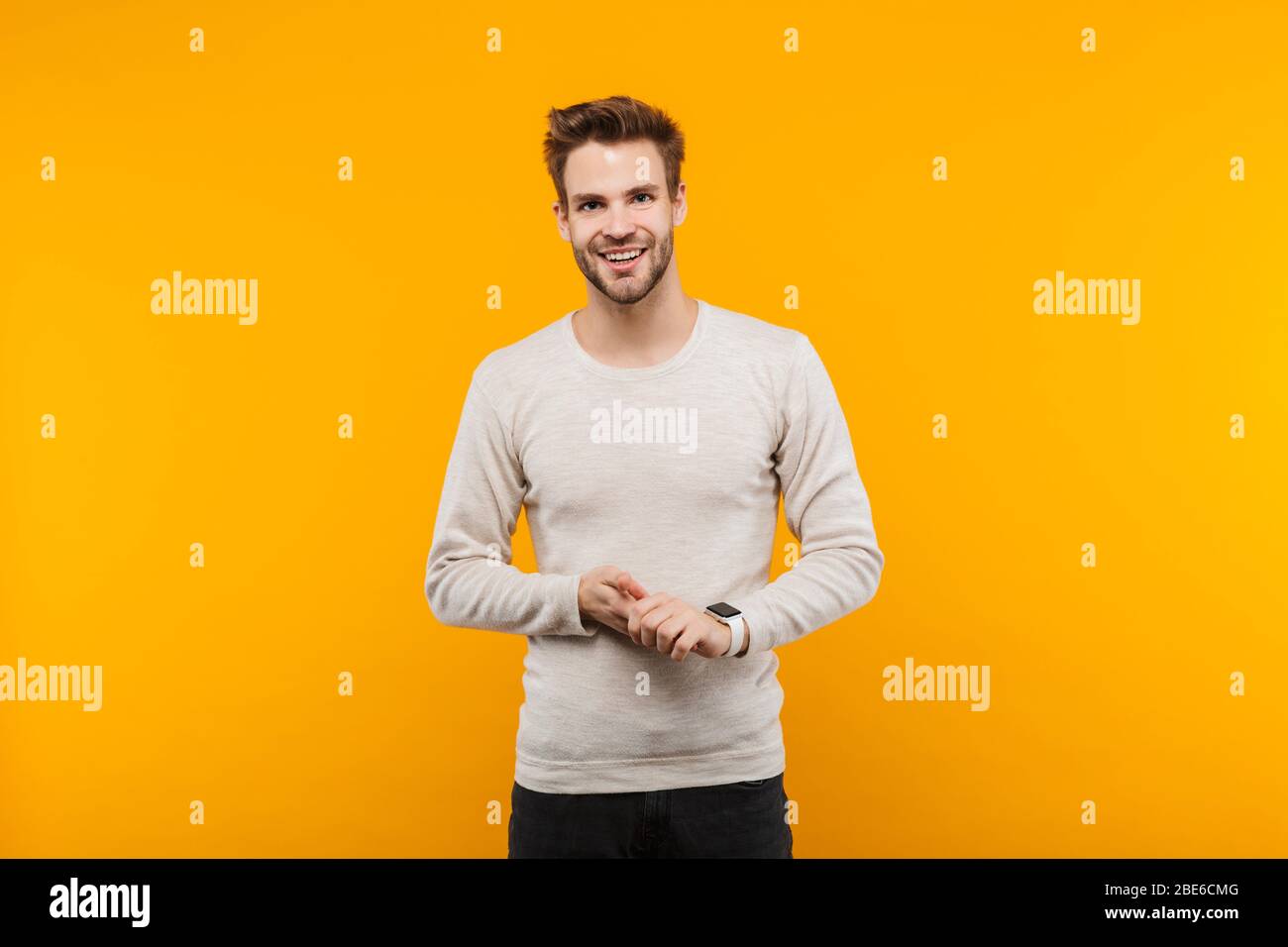 Attractive happy young man wearing pullower standing isolated over ...