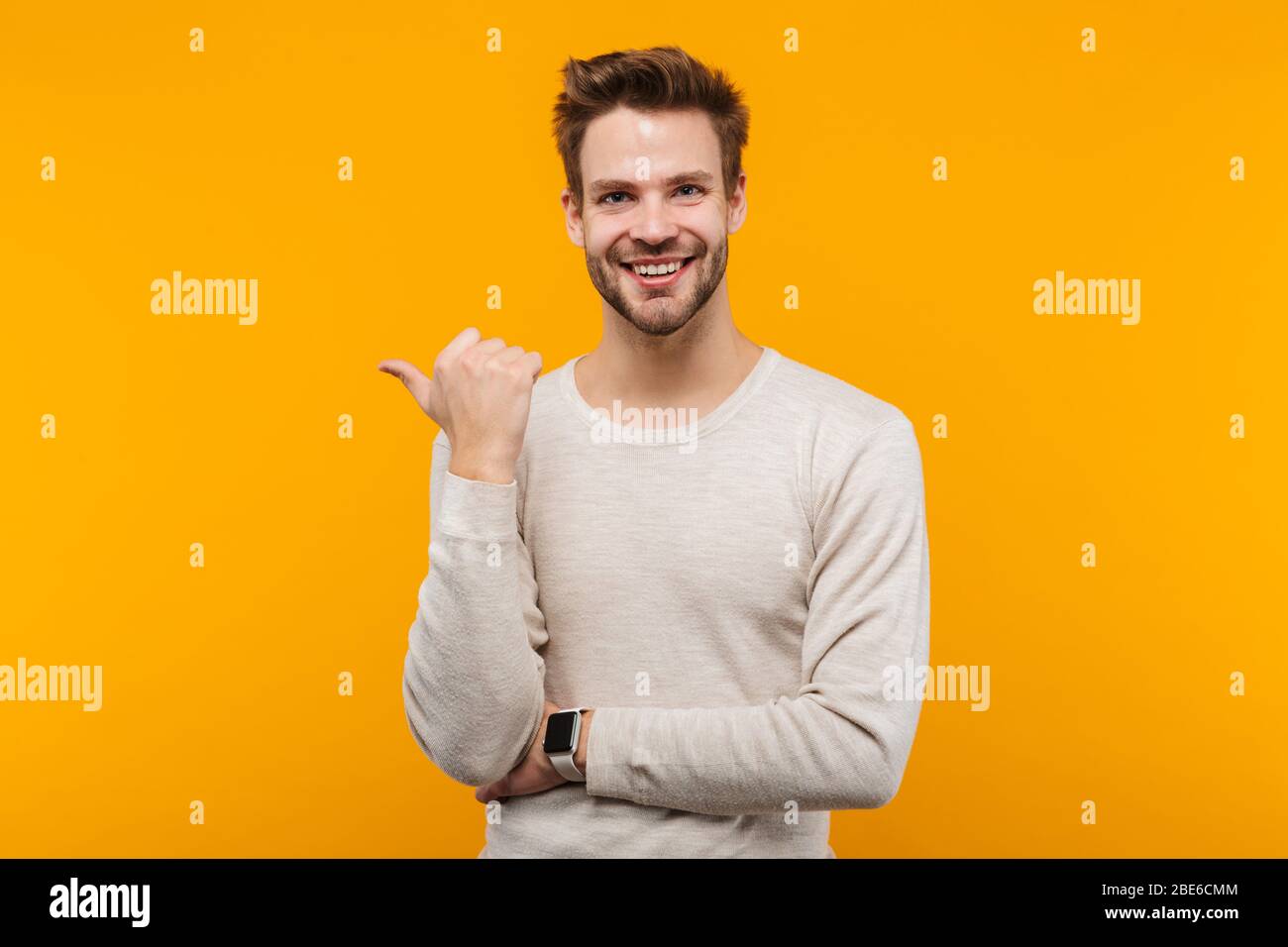 Attractive happy young man wearing pullower standing isolated over ...