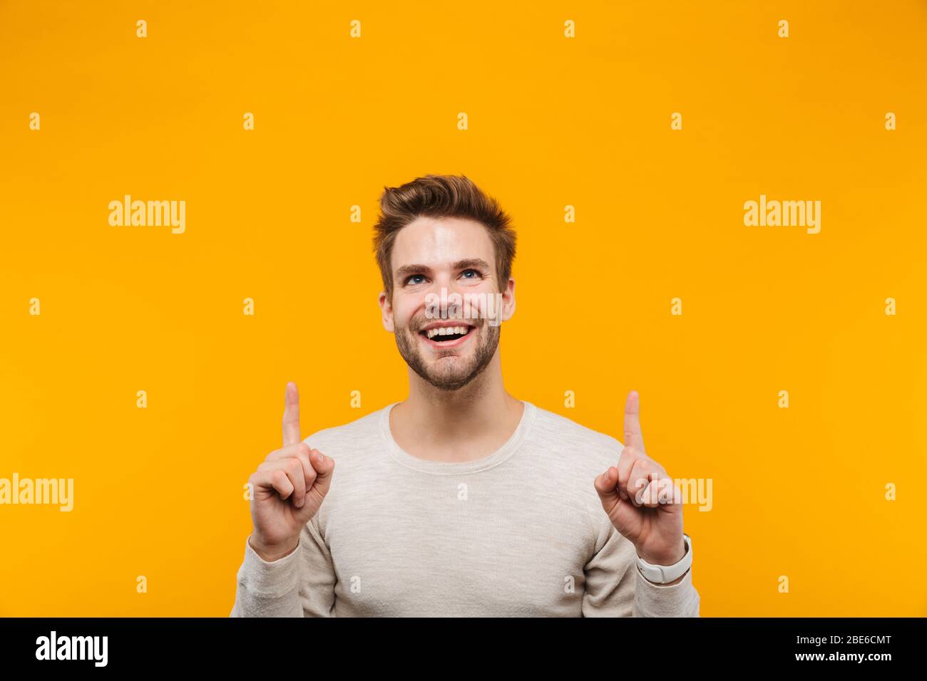 Attractive happy young man wearing pullower standing isolated over ...