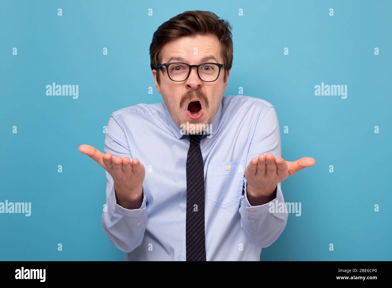 Angry young man in glasses having a quarrel with his business partner ...