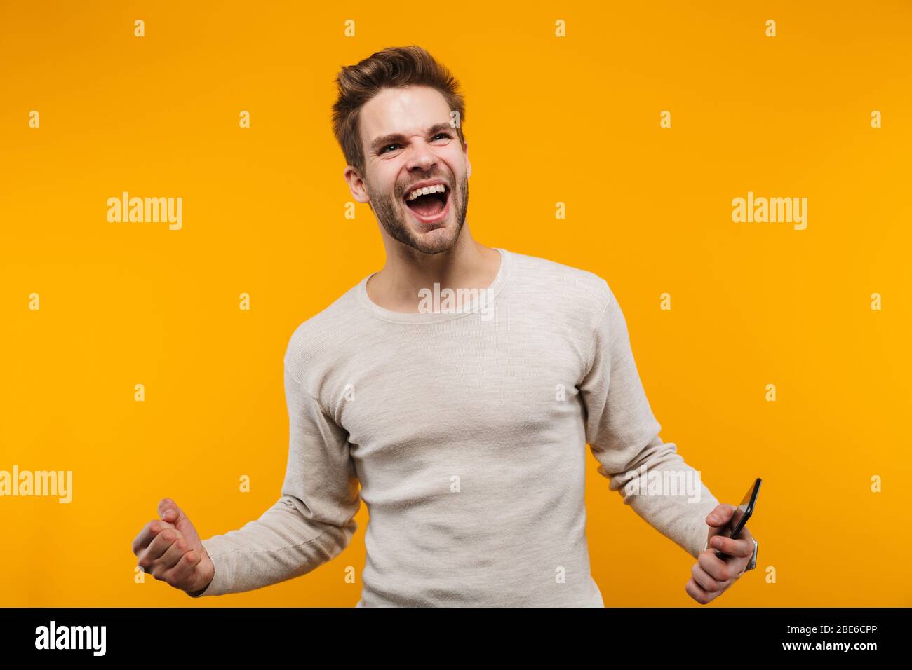 Attractive happy young man wearing pullower standing isolated over ...