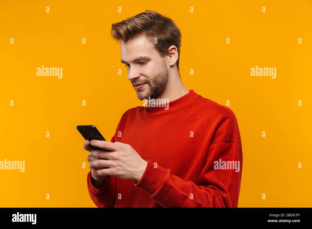 Attractive young man wearing pullower standing isolated over yellow ...