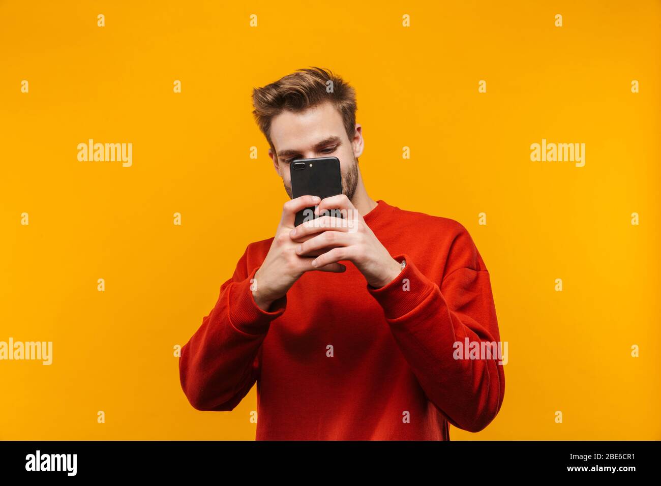 Attractive young man wearing pullower standing isolated over yellow ...