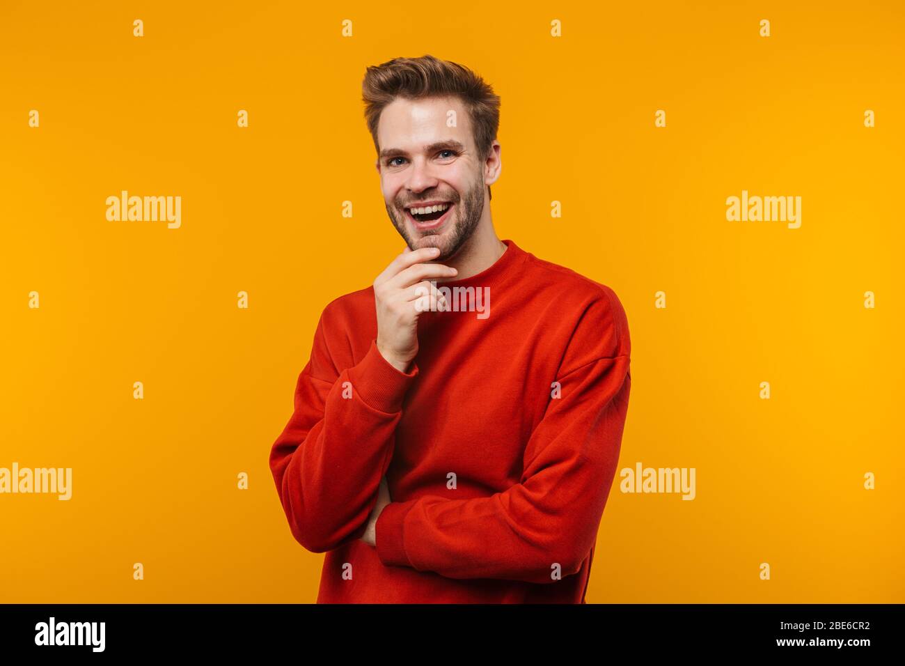 Attractive happy young man wearing pullower standing isolated over ...