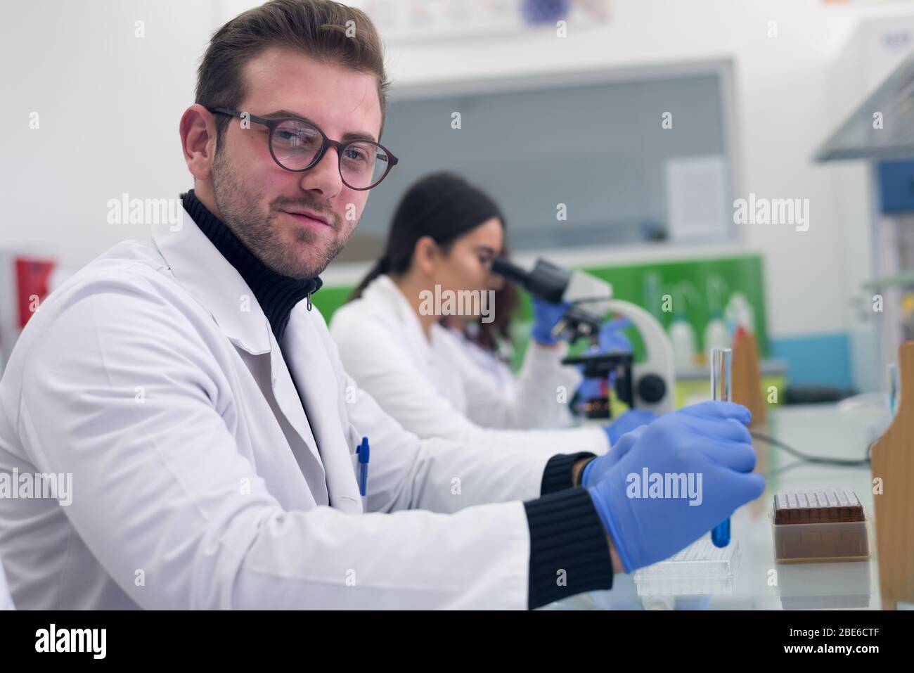 Group of Laboratory scientists working at lab with test tubes, test or ...