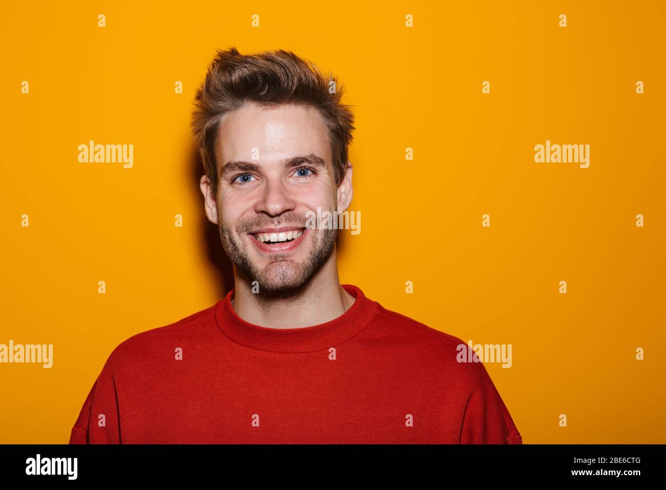Attractive happy young man wearing pullower standing isolated over ...