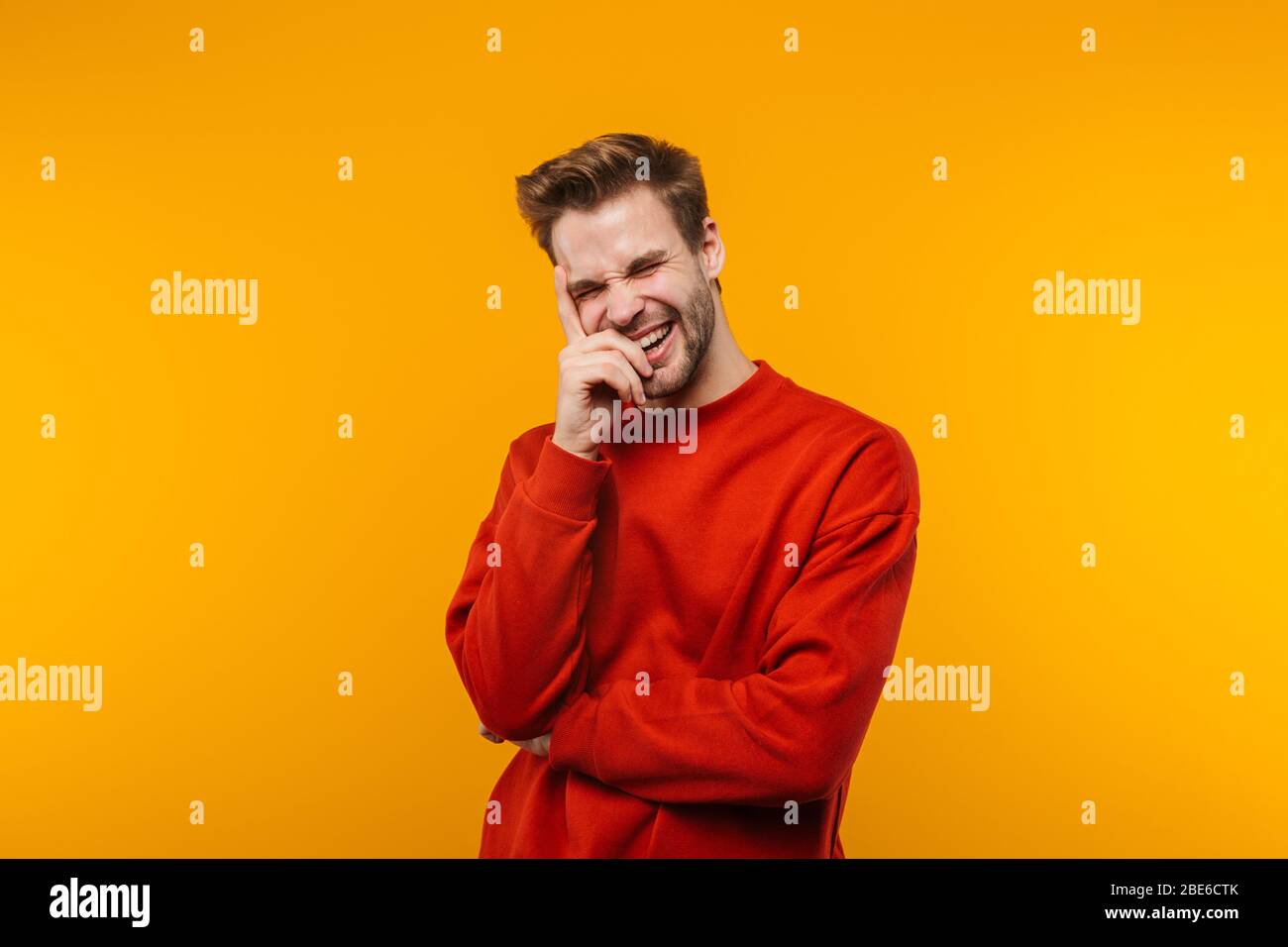 Attractive happy young man wearing pullower standing isolated over ...