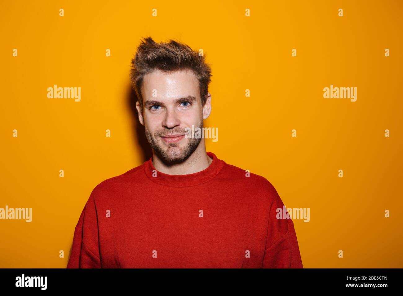 Attractive happy young man wearing pullower standing isolated over ...