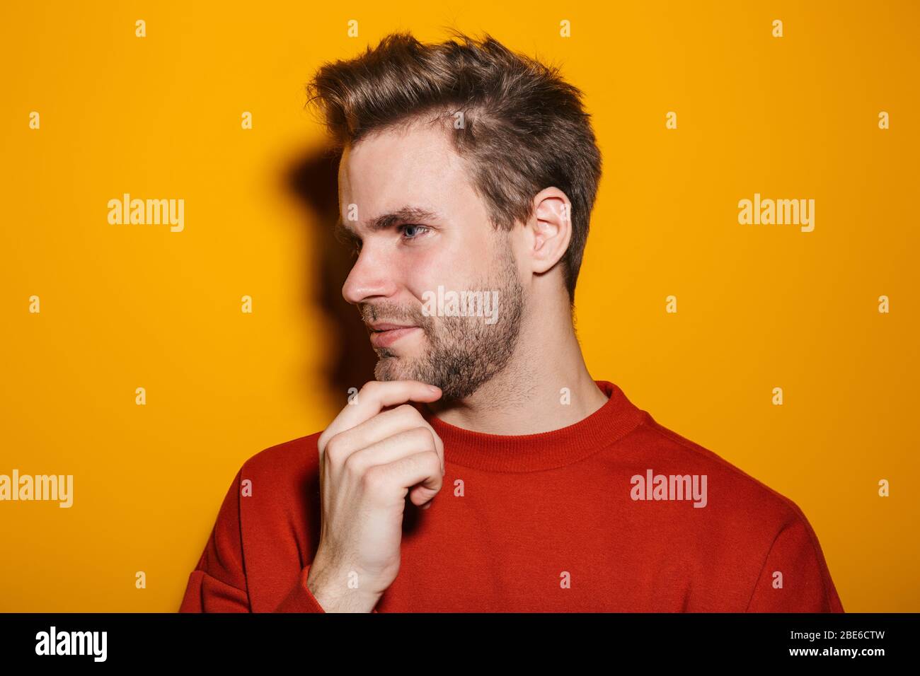 Attractive young man wearing pullower standing isolated over yellow ...