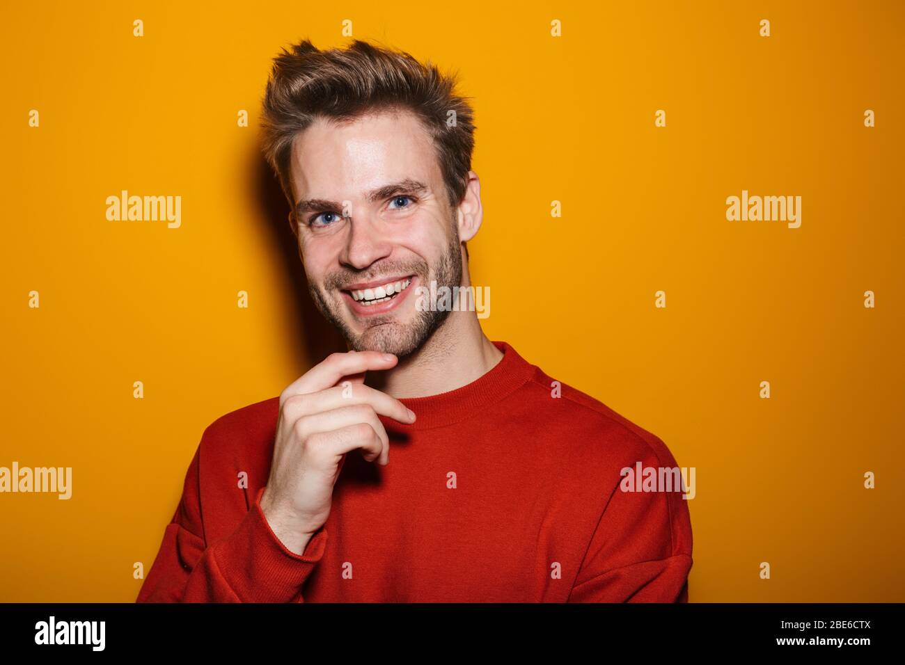 Attractive happy young man wearing pullower standing isolated over ...
