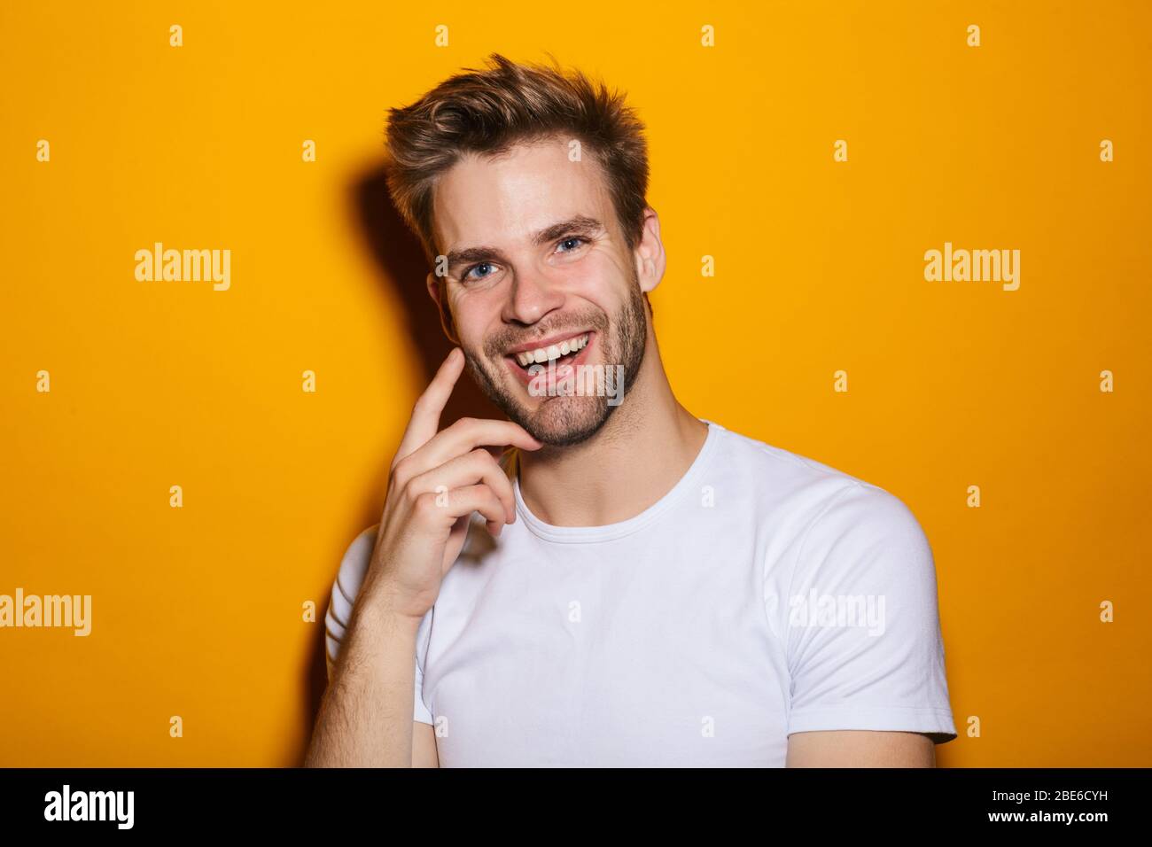 Attractive happy pensive young man wearing pullower standing isolated over yellow background ...