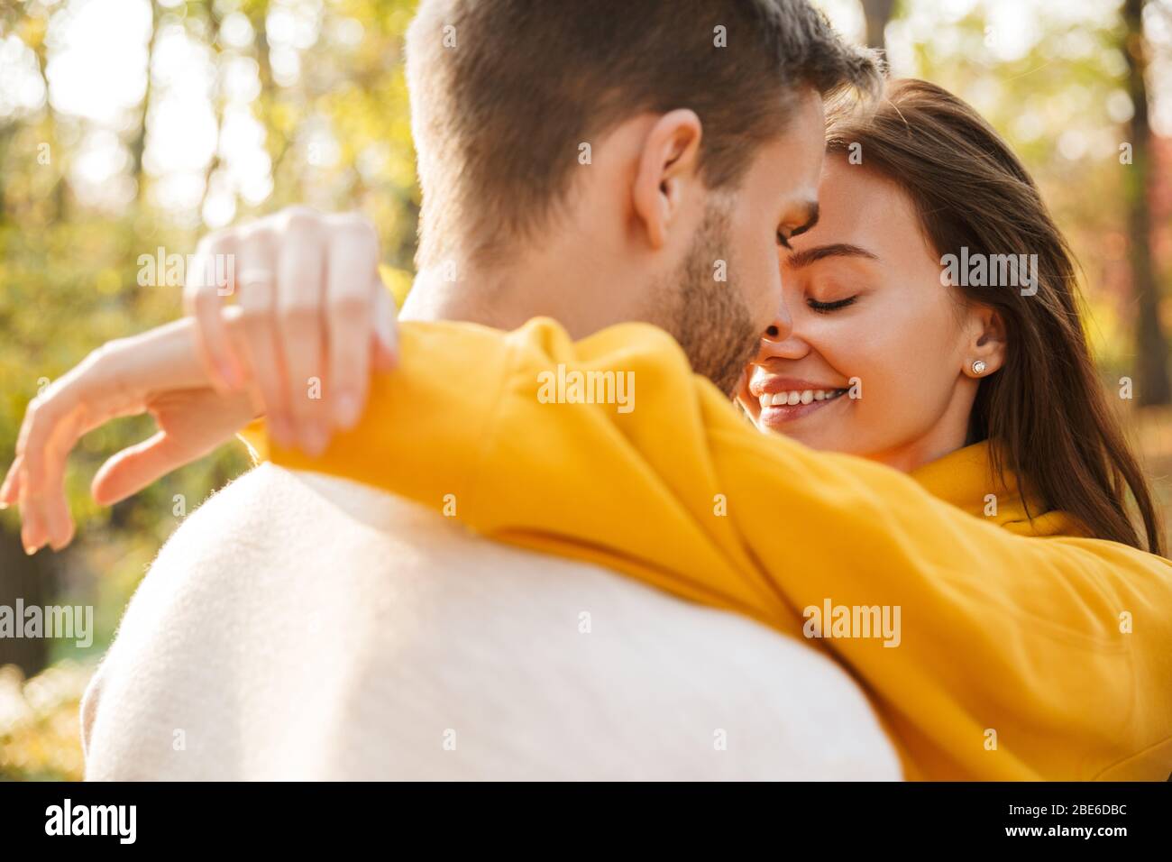 Image of attractive young caucasian couple in love hugging while ...