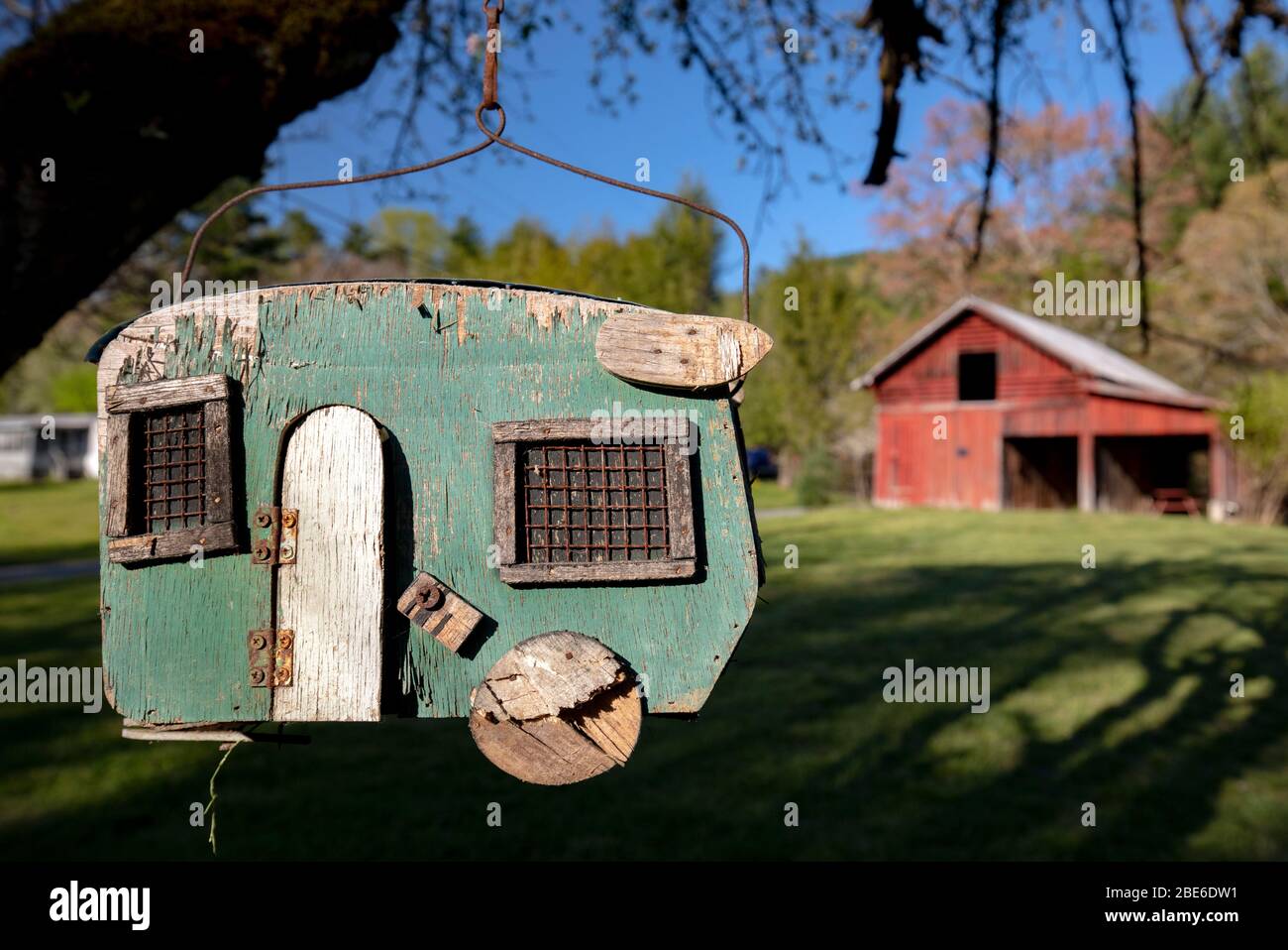 Retro wooden camper trailer birdhouse with red barn in the background ...
