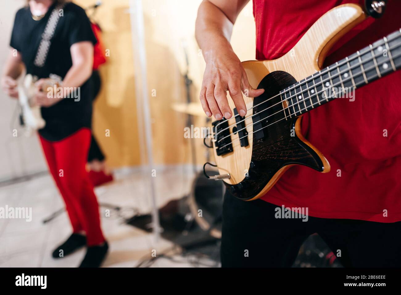 Rock band studio rehearsal. Male musician playing bass guitar before ...
