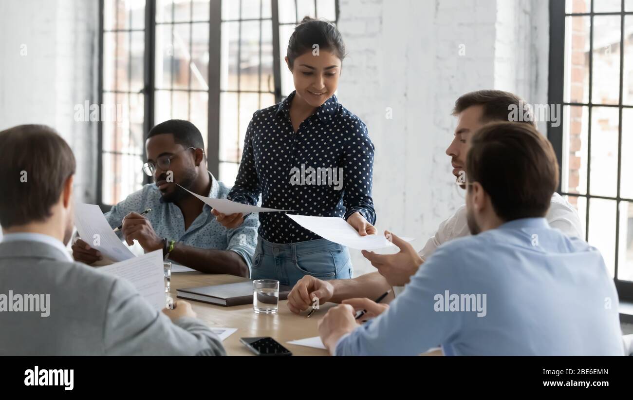 Young indian team leader share handouts at meeting Stock Photo - Alamy