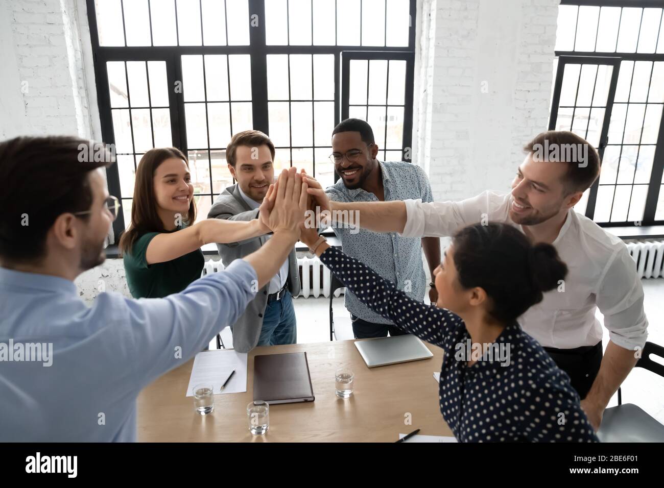 Excited diverse colleagues give high five celebrate success Stock Photo ...