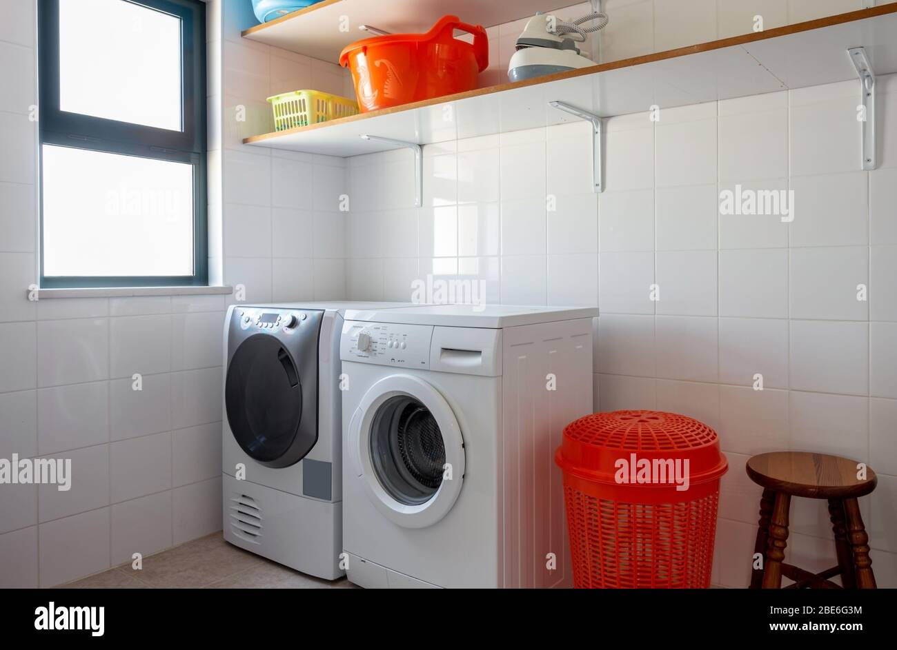 Laundry room interior with washing machine and clothes dryer near wall ...
