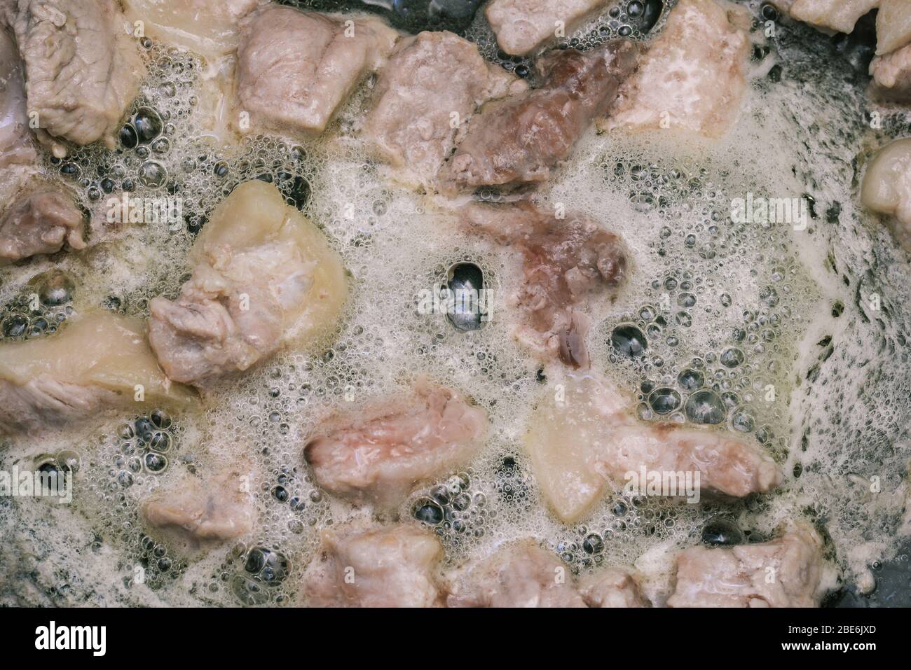 The process of cooking fried meat. Pieces of pork fillet are fried in a ...