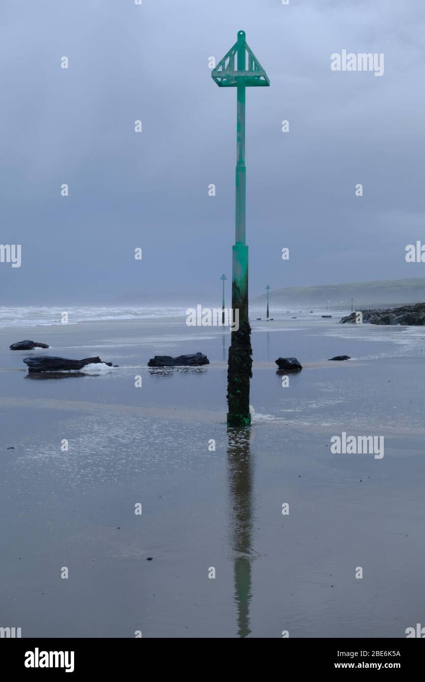 marker post on the beach at Borth on the west coast of Wales Stock ...