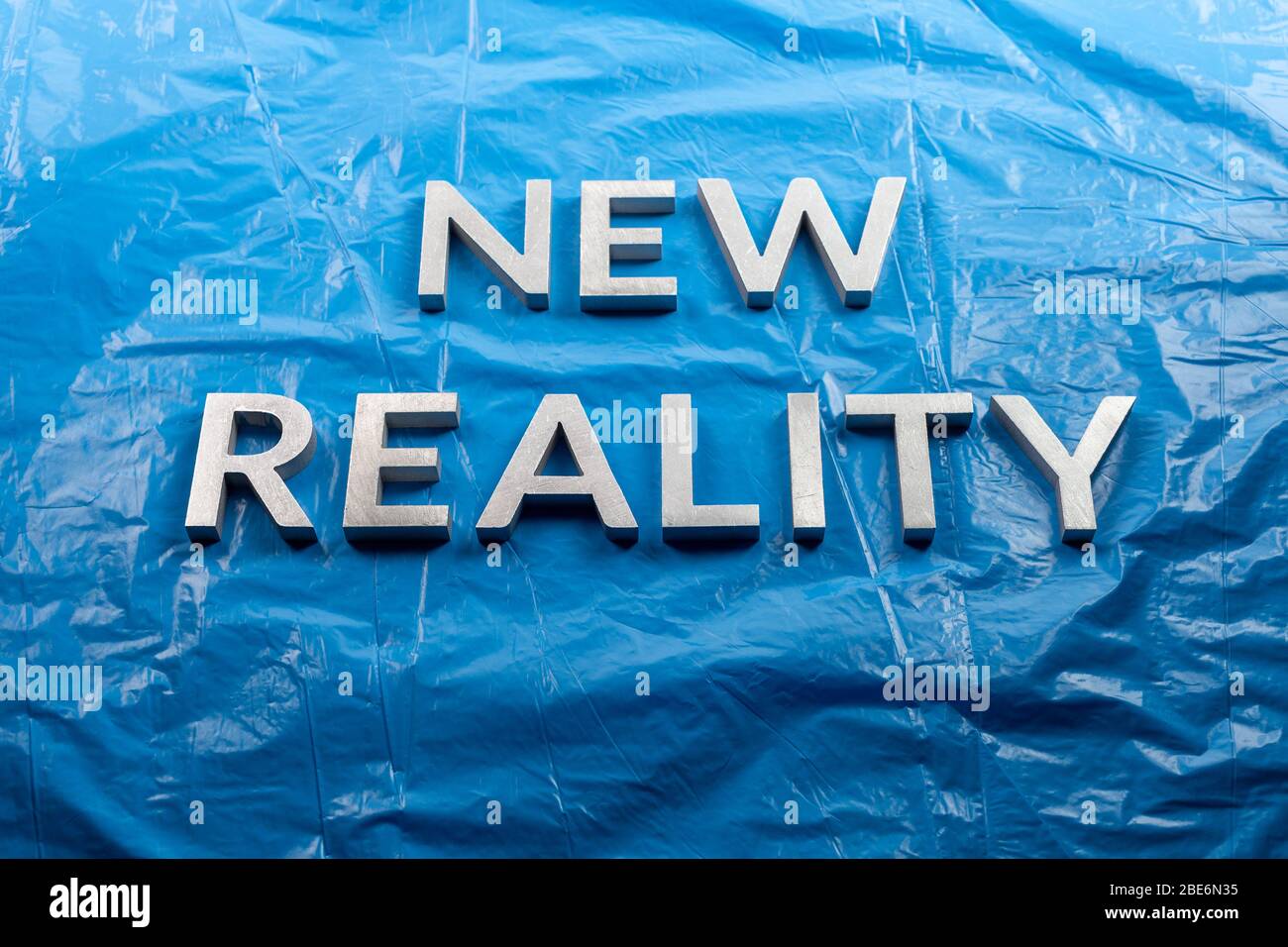the words new reality laid with white letters over crumpled blue ...