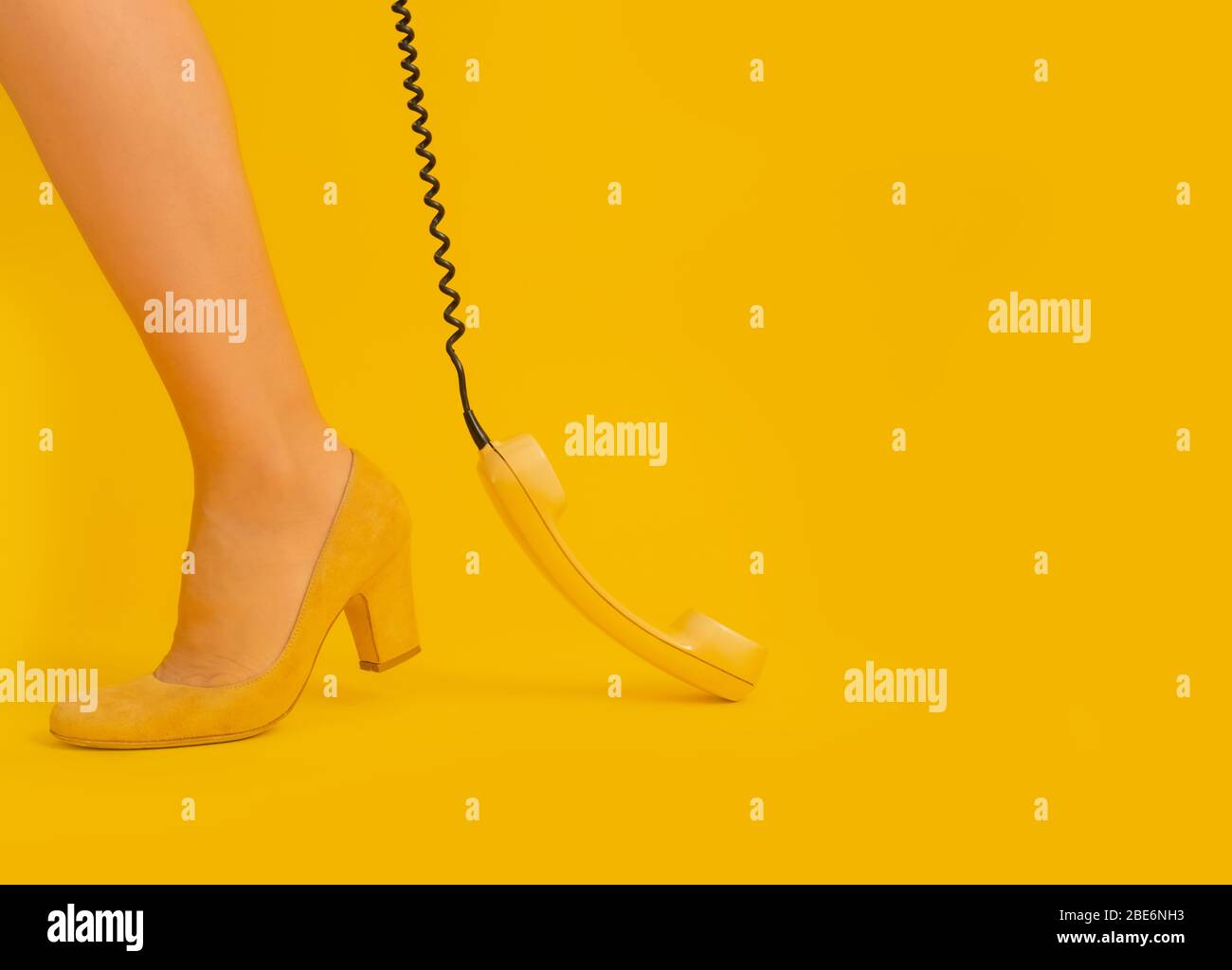 Woman's legs in the yellow shoes on a yellow background with old ...