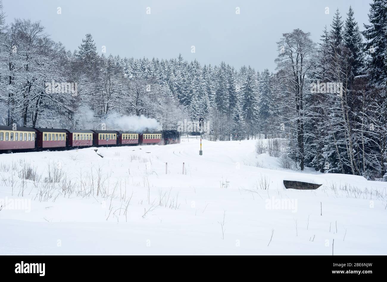 Old steam train near the german Harz mountains driving through a valley ...