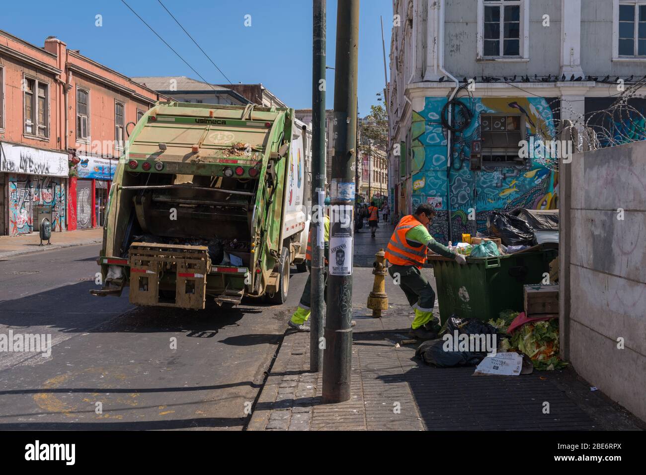 Garbage workers collect houses while collecting garbage containers on ...