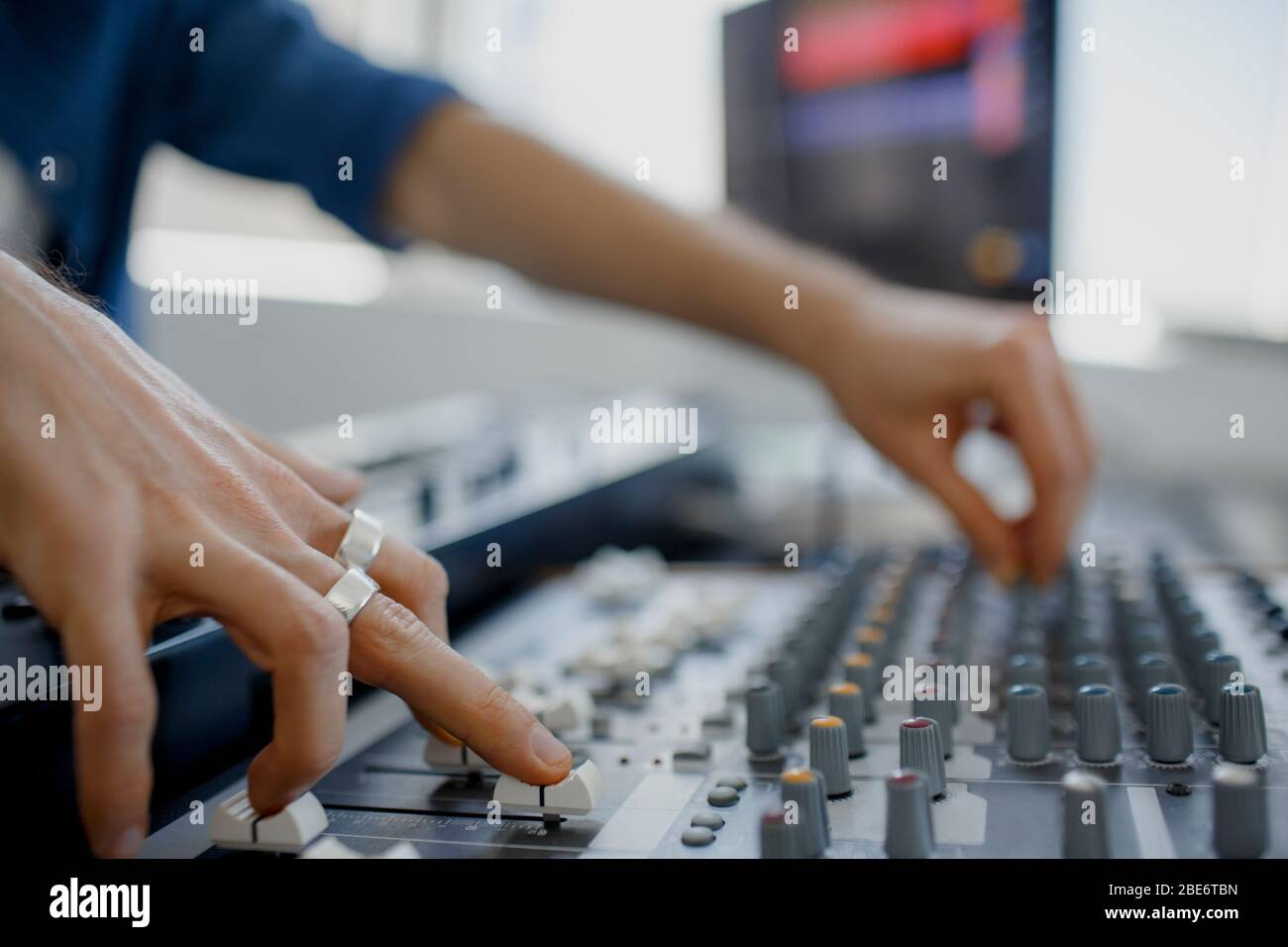 Hand on a mixer, operating the leader. Sound engineer working at mixing ...