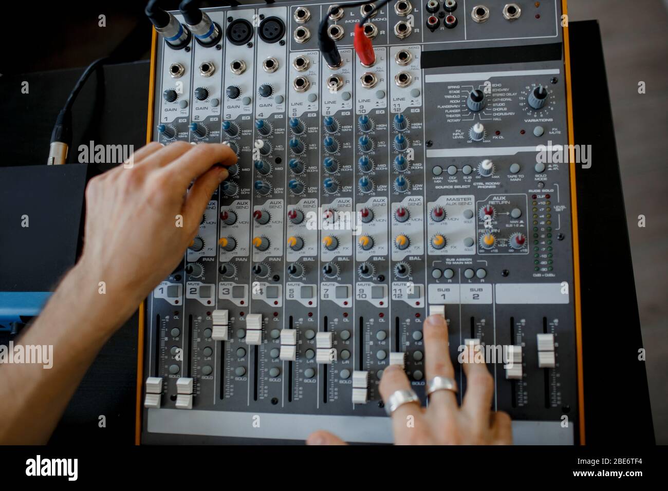 Hand on a mixer, operating the leader. Sound engineer working at mixing ...