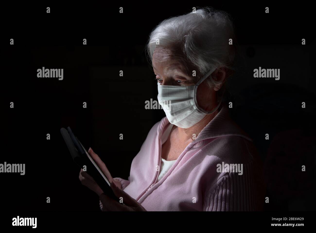 Senior woman with face mask chats with tablet computer Stock Photo - Alamy