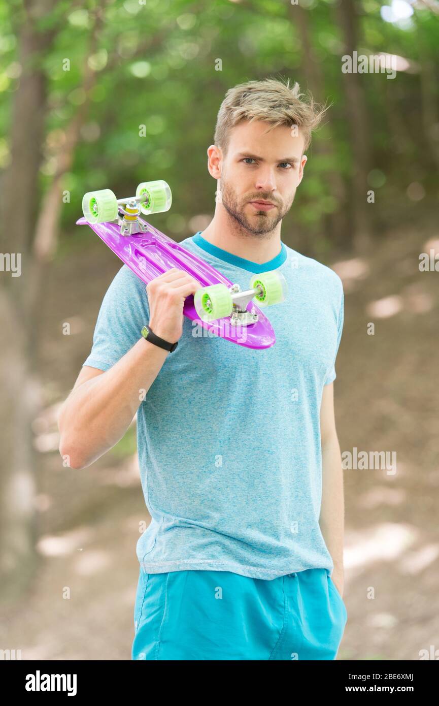 Penny board is his travel companion. Handsome guy hold penny board ...