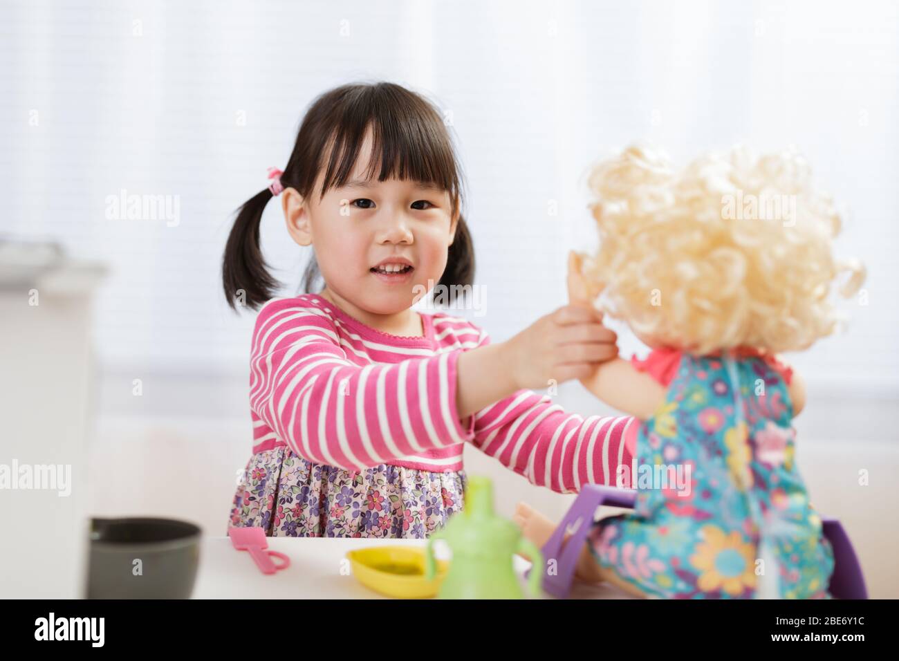 Toddler feeding baby doll hi-res stock photography and images - Alamy