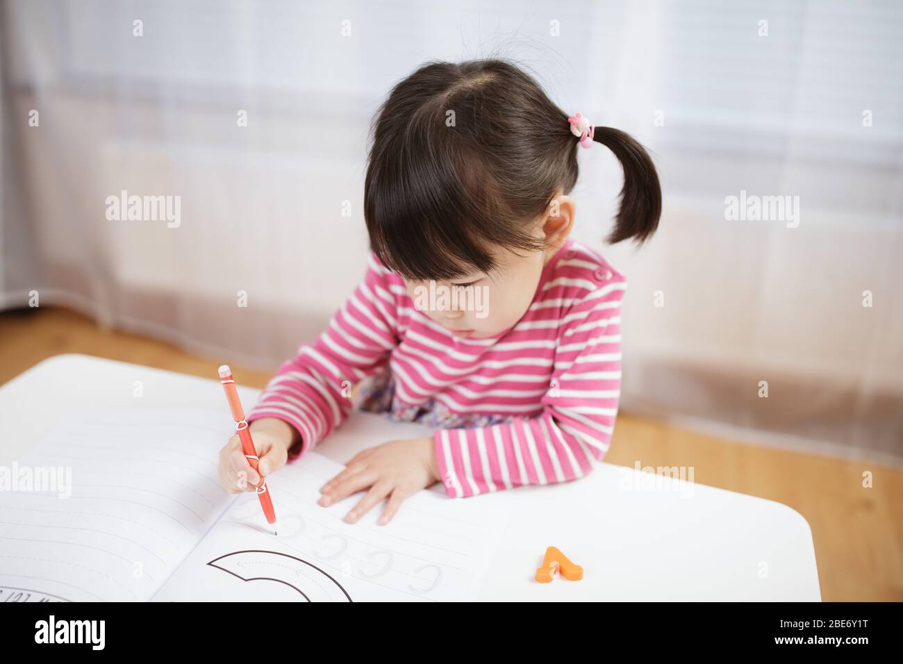 toddler girl practice writing letters for homeschooling Stock Photo - Alamy