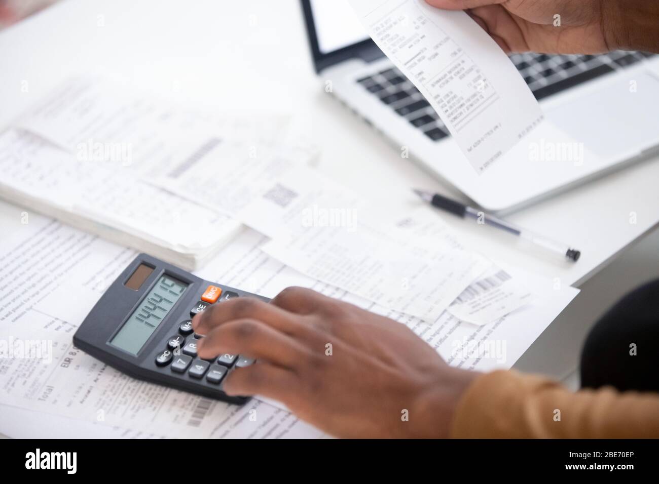 Close up african american man hand using calculator and laptop Stock ...