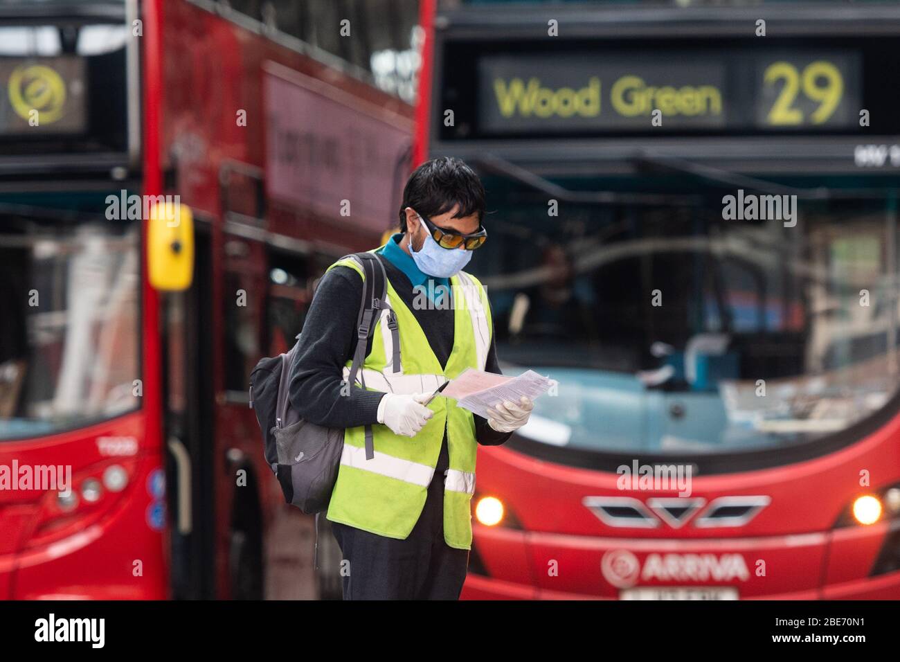 Asian bus supervisor wearing mask in bus garage, scheduling bus service ...