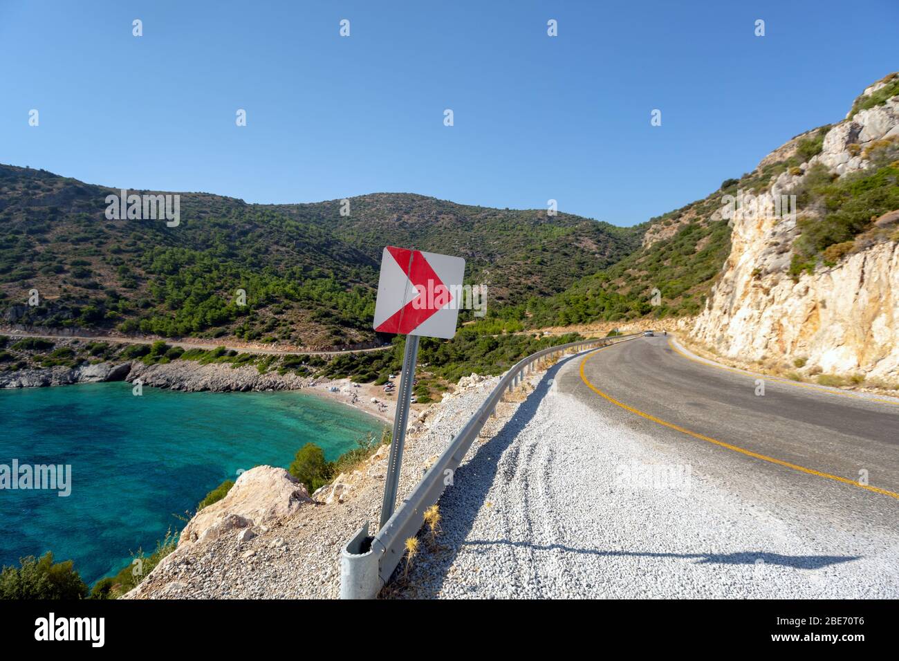 Curved mediterranean asphalt road going to the turquoise colored waters ...