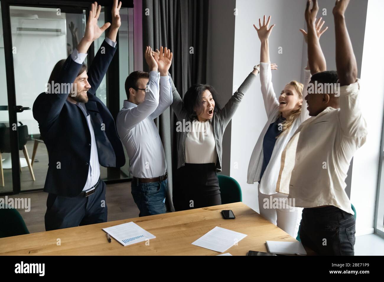 Excited diverse colleagues participate in motivational business ...