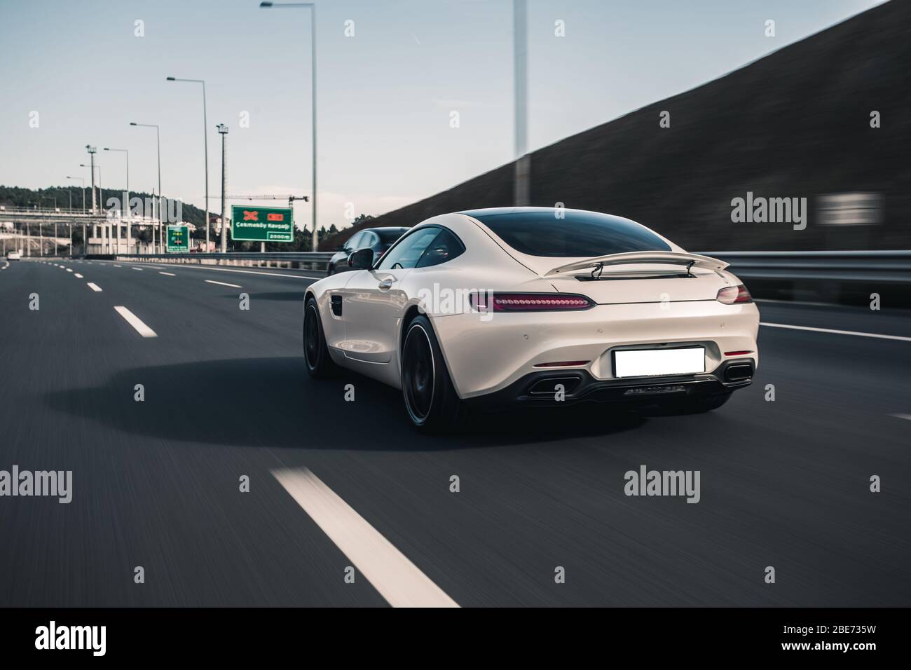 White luxury model sport car profile view on the highway across ...