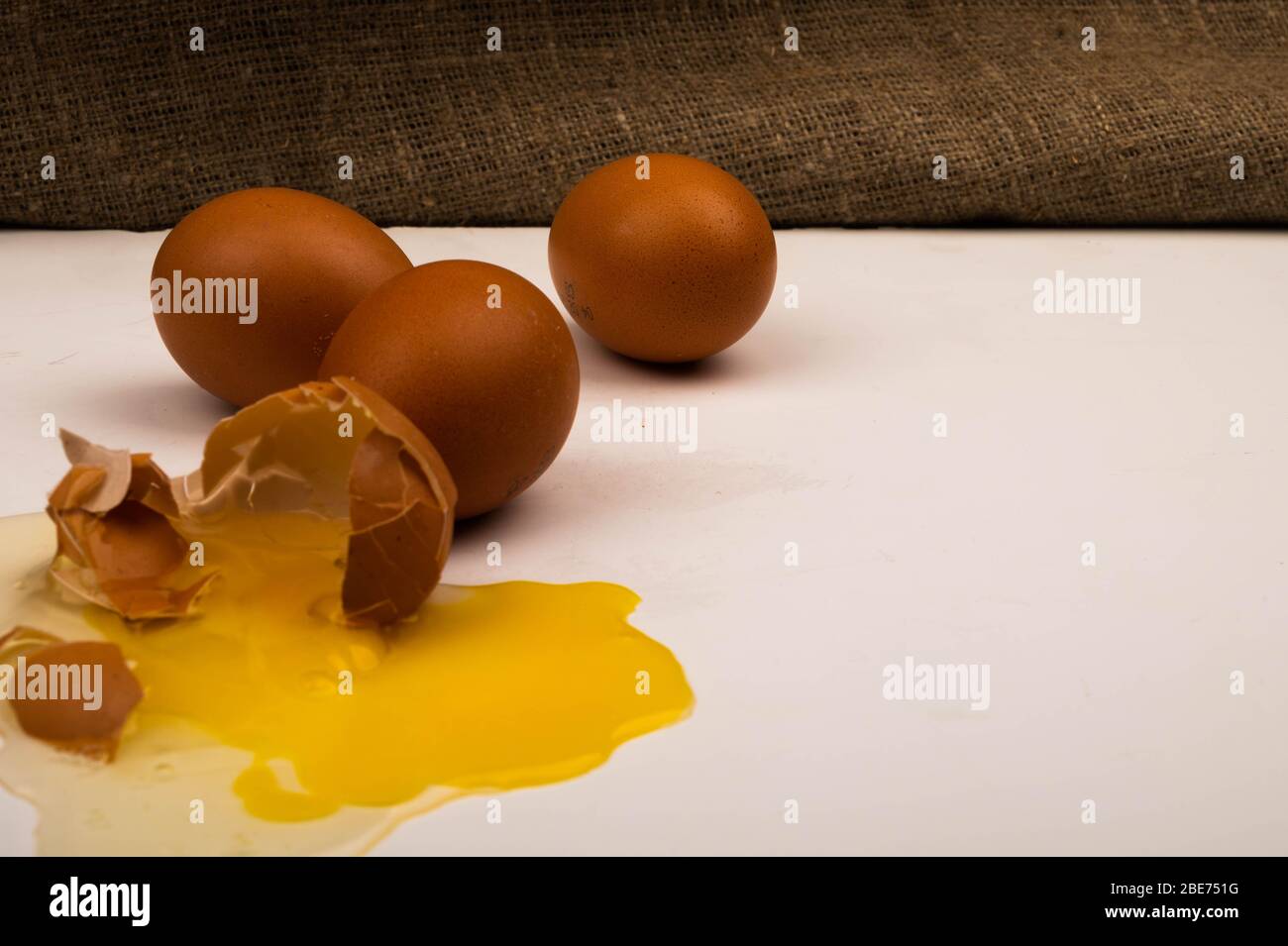 Broken chicken egg and chicken eggs scattered on a white background ...
