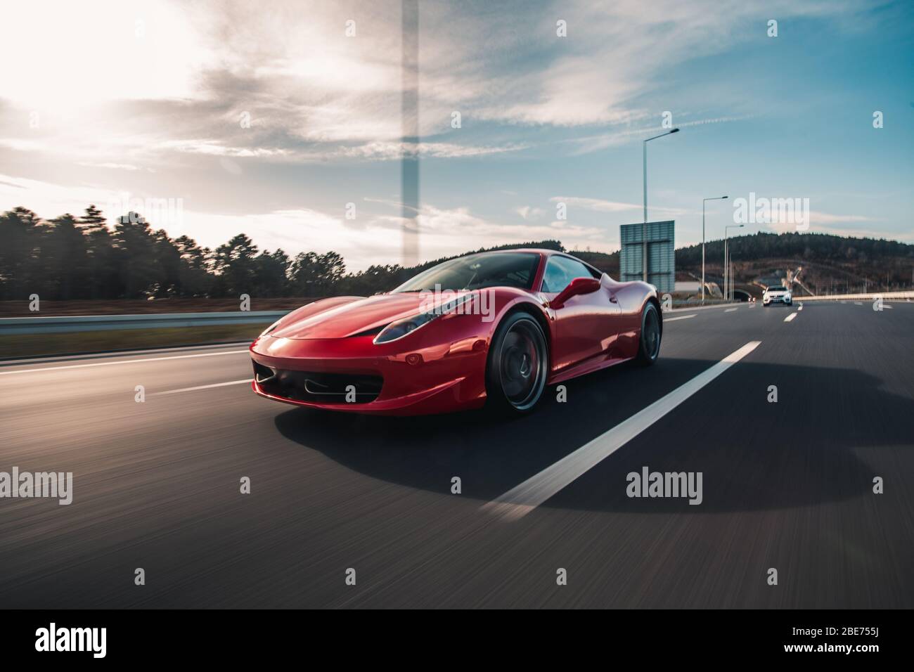 Red luxury model sport car profile view on the highway ,front view ...