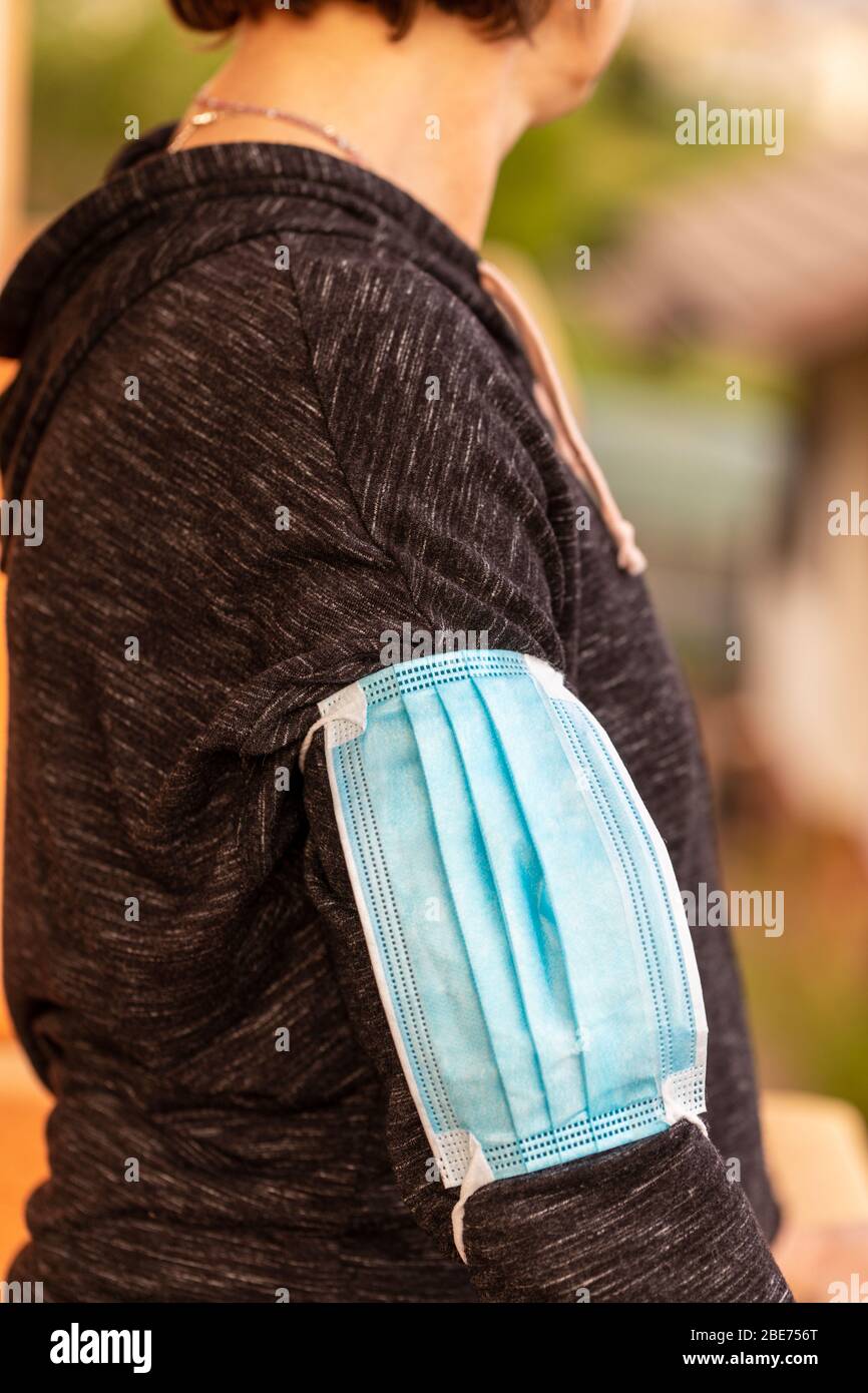 Woman showing the wrong way to wear a face mask as protection against ...
