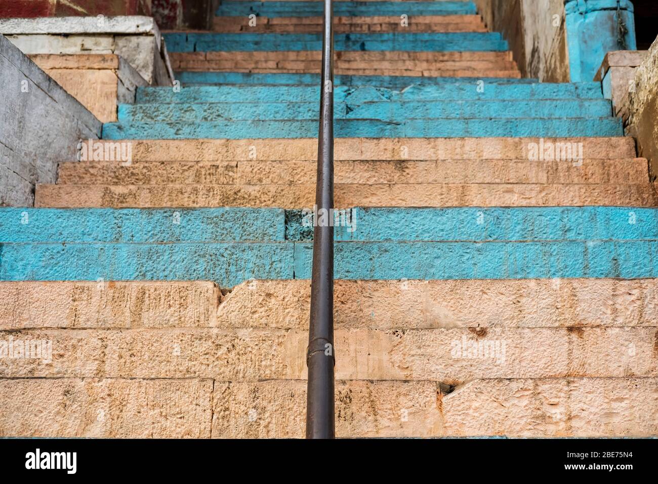 stone stairs painted in blue stripes leading to the Ganga river in ...