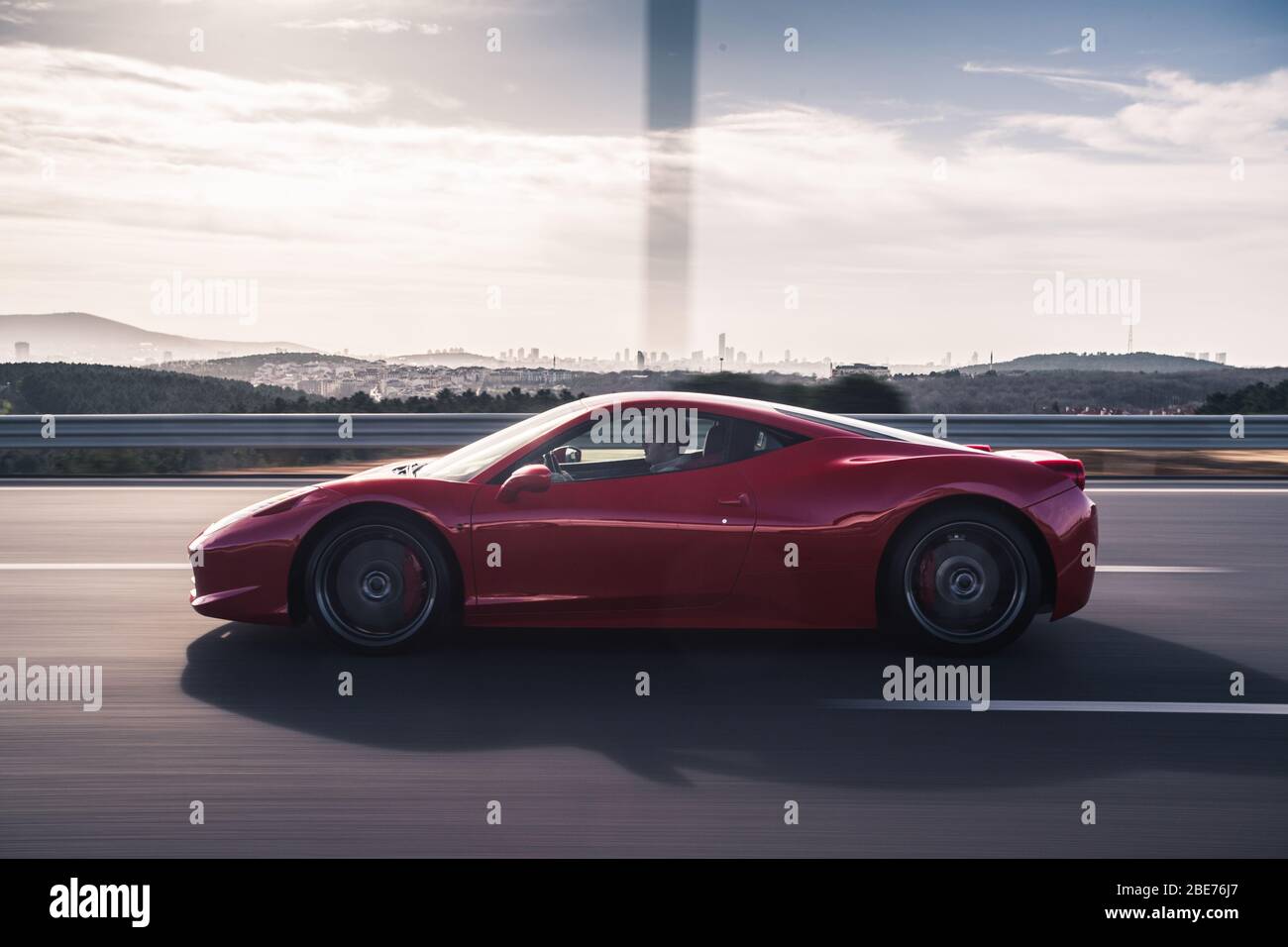 Red luxury model sport car profile view on the highway in the daytime ...