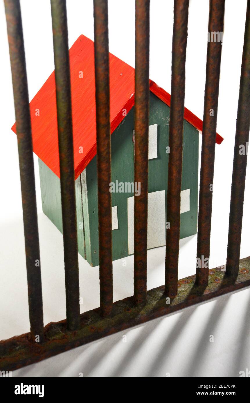 A house behind bars to illustrate the impact on households of the ...