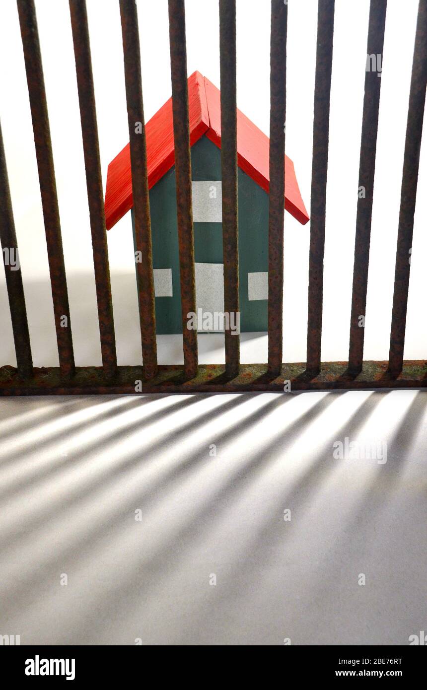 A house behind bars to illustrate the impact on households of the ...