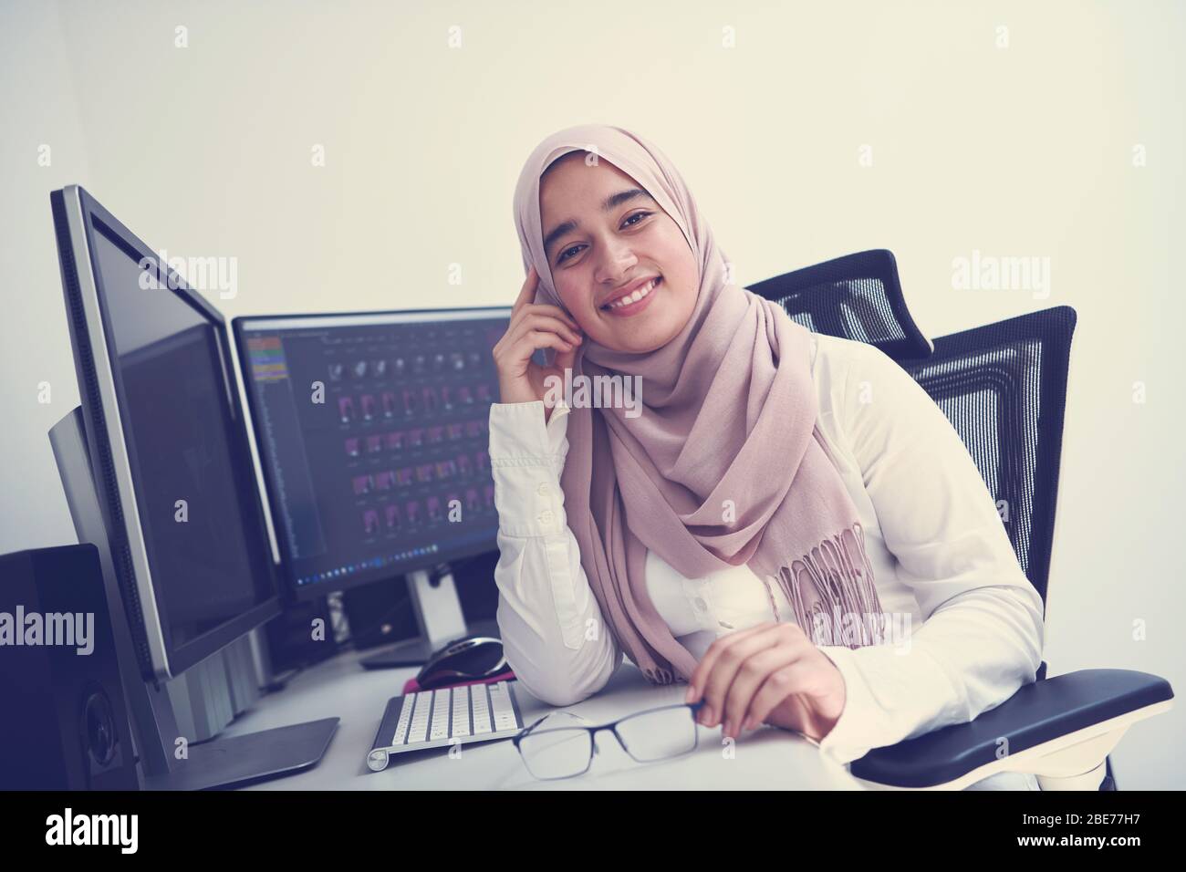 female Arabic creative professional working at home office on desktop ...