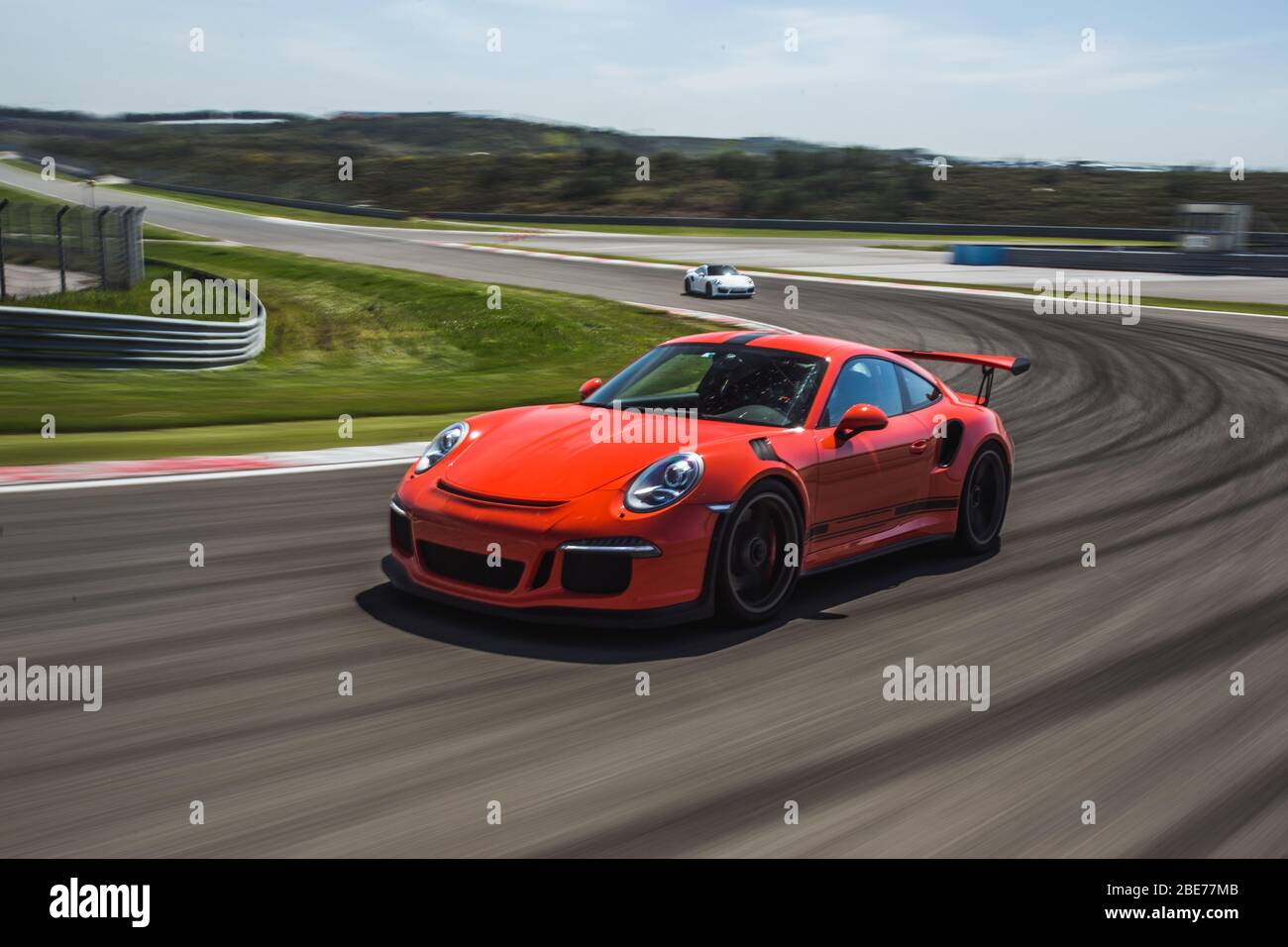 Red sport car racing on the trace with other cars Stock Photo - Alamy