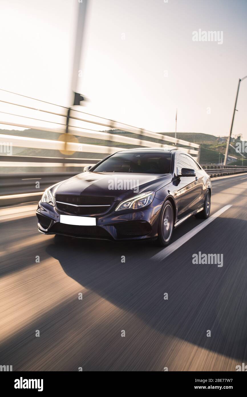 Black sedan car driving over the bridge Stock Photo - Alamy