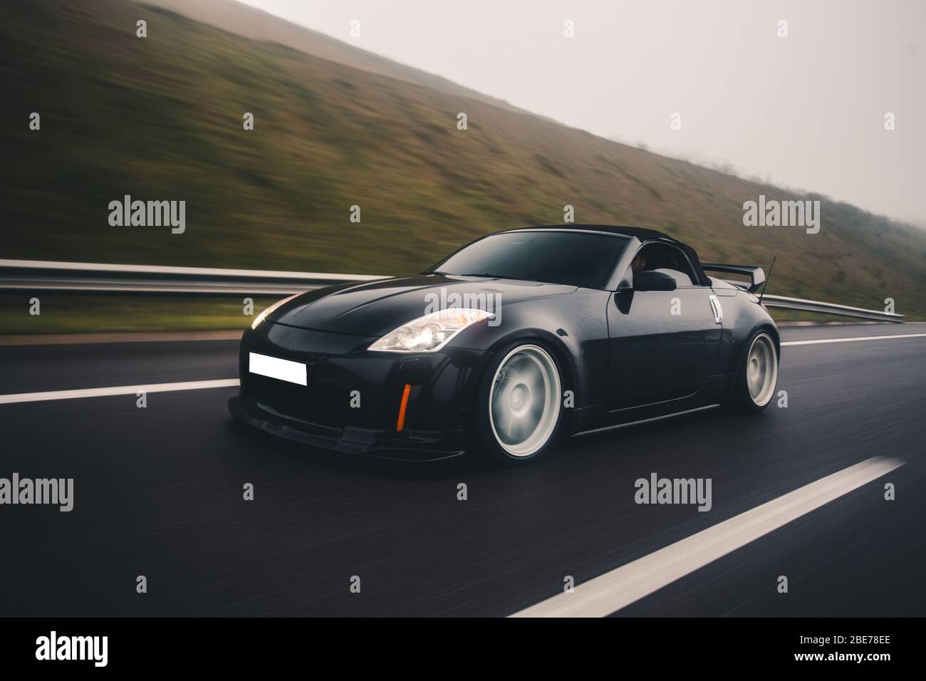 Black sport car high speed drive across mountains, front view Stock ...
